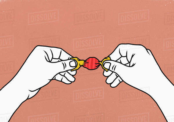 Hands opening wrapped candy - Stock Photo - Dissolve