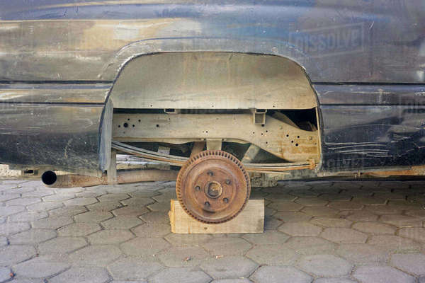 Rusted car missing wheel - Royalty-free Stock Photo | Dissolve