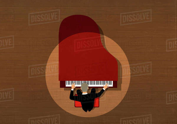 Concert pianist performing at grand piano on stage under spotlight ...