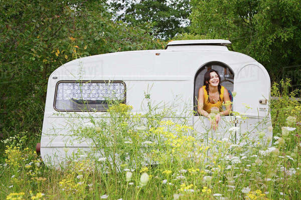 Happy young woman in camper trail in meadow - Royalty-free Stock Photo ...