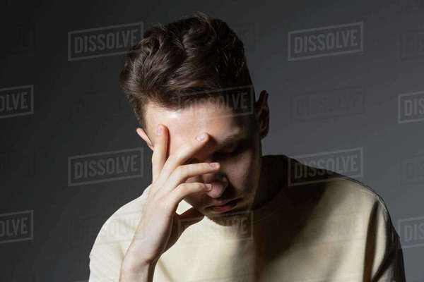 Tired young man with head in hands - Royalty-free Stock Photo | Dissolve