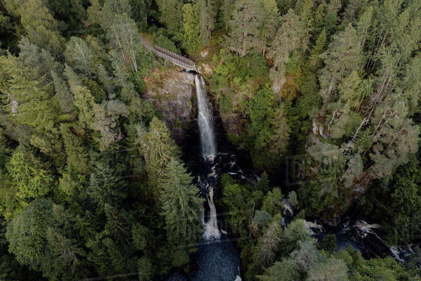 Aerial view of waterfall among forest trees, Plodda Falls, Inverness ...