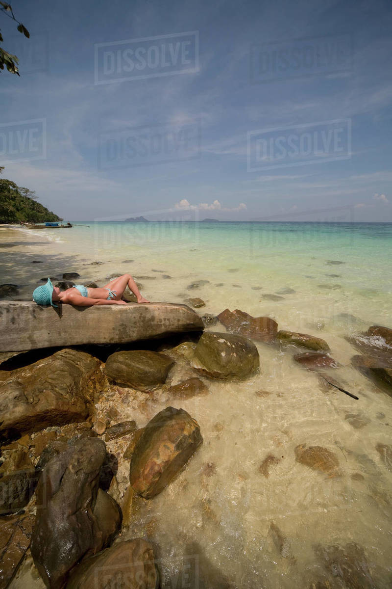 Young woman lying on rocks sunbathing and relaxing, Koh Phi Phi, Thailand - Royalty-free Stock ...
