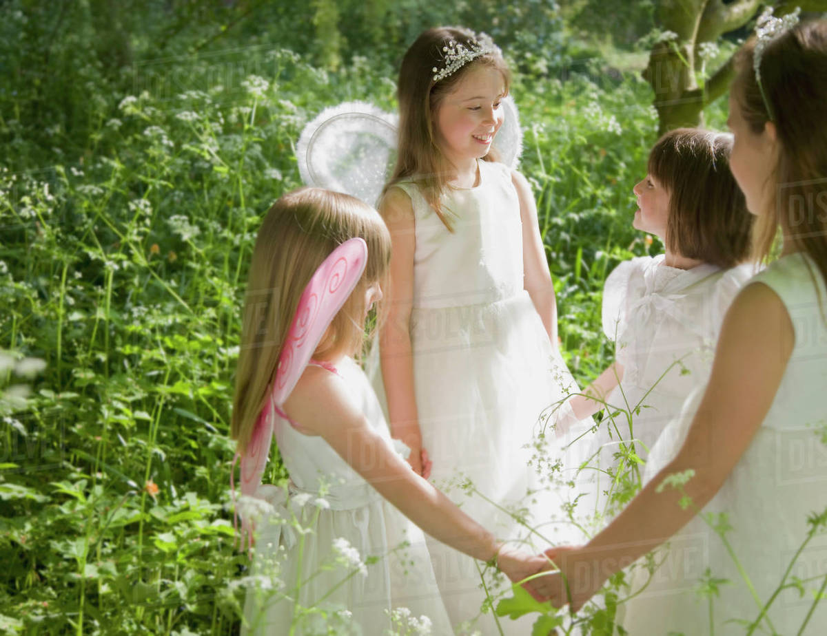Young girls in fancy dress holding hands in a garden - Royalty-free ...