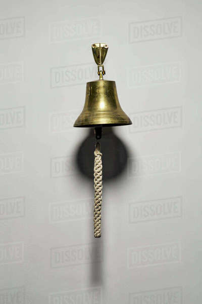 Brass bell with rope pull hanging on wall - Royalty-free Stock Photo ...