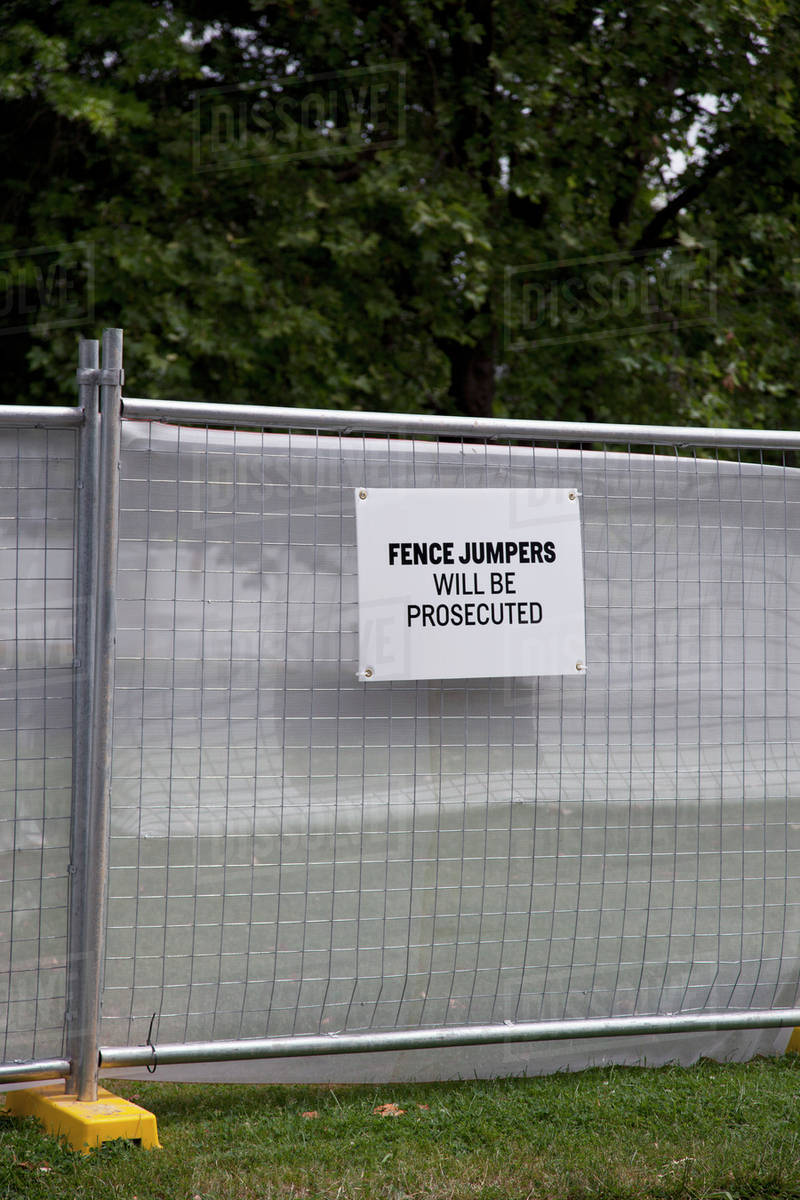 Detail of a fence with a warning sign - Stock Photo - Dissolve
