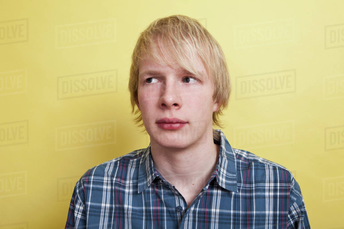 A teenage boy looking off to the side with curiosity, portrait, studio ...