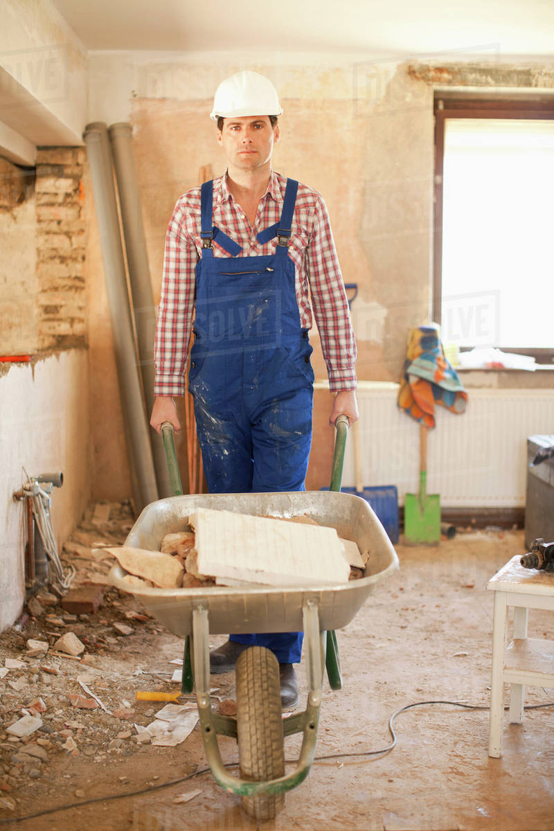A manual worker pushing a wheelbarrow - Royalty-free Stock Photo | Dissolve