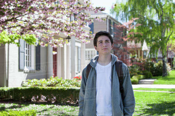 Boy standing still outside and looking up - Stock Photo - Dissolve