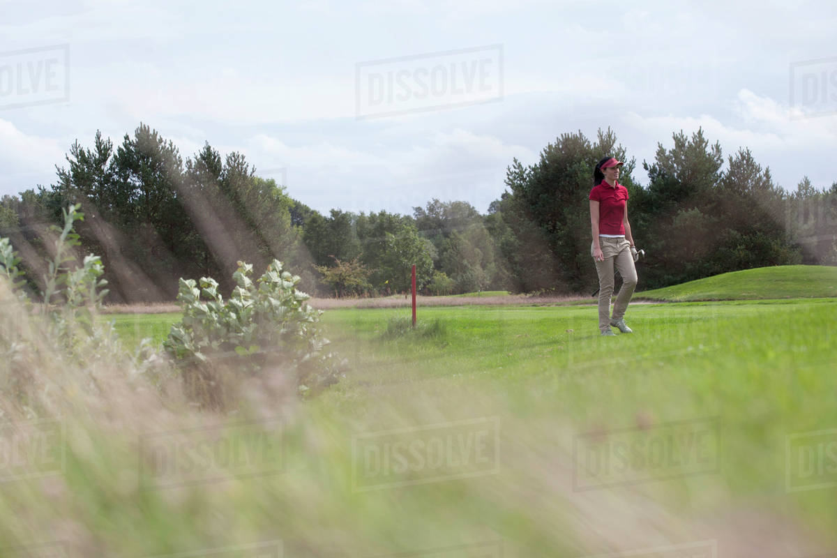 A female golfer walking on a golf course - Stock Photo - Dissolve